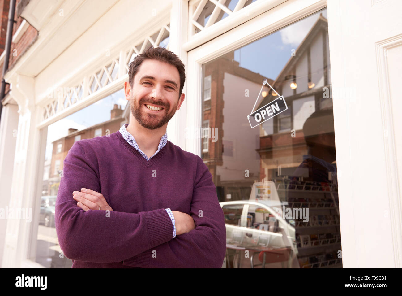 Shop owner standing next to his shop Stock Photo - Alamy