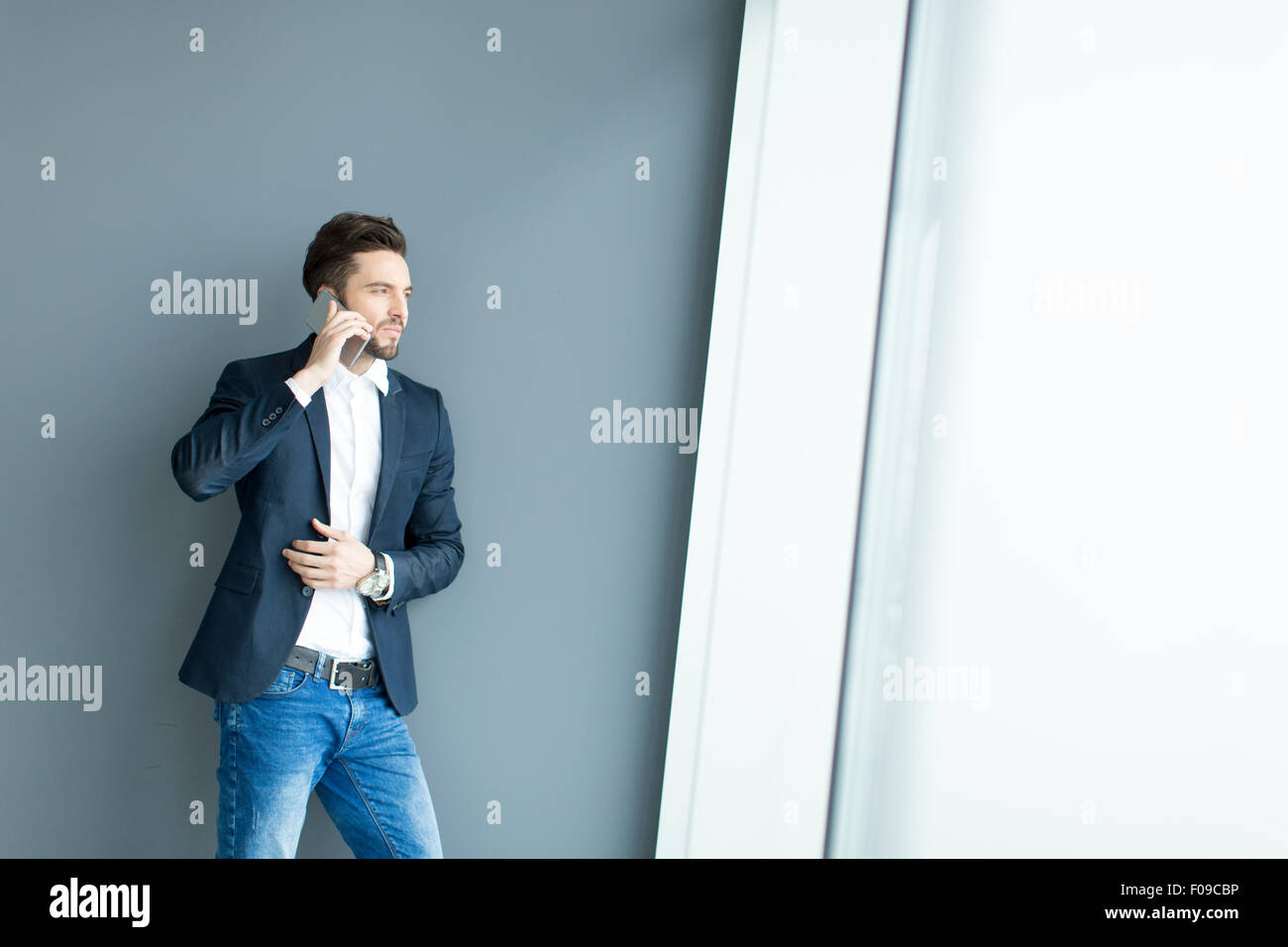 Young man with mobile phone in the office Stock Photo - Alamy
