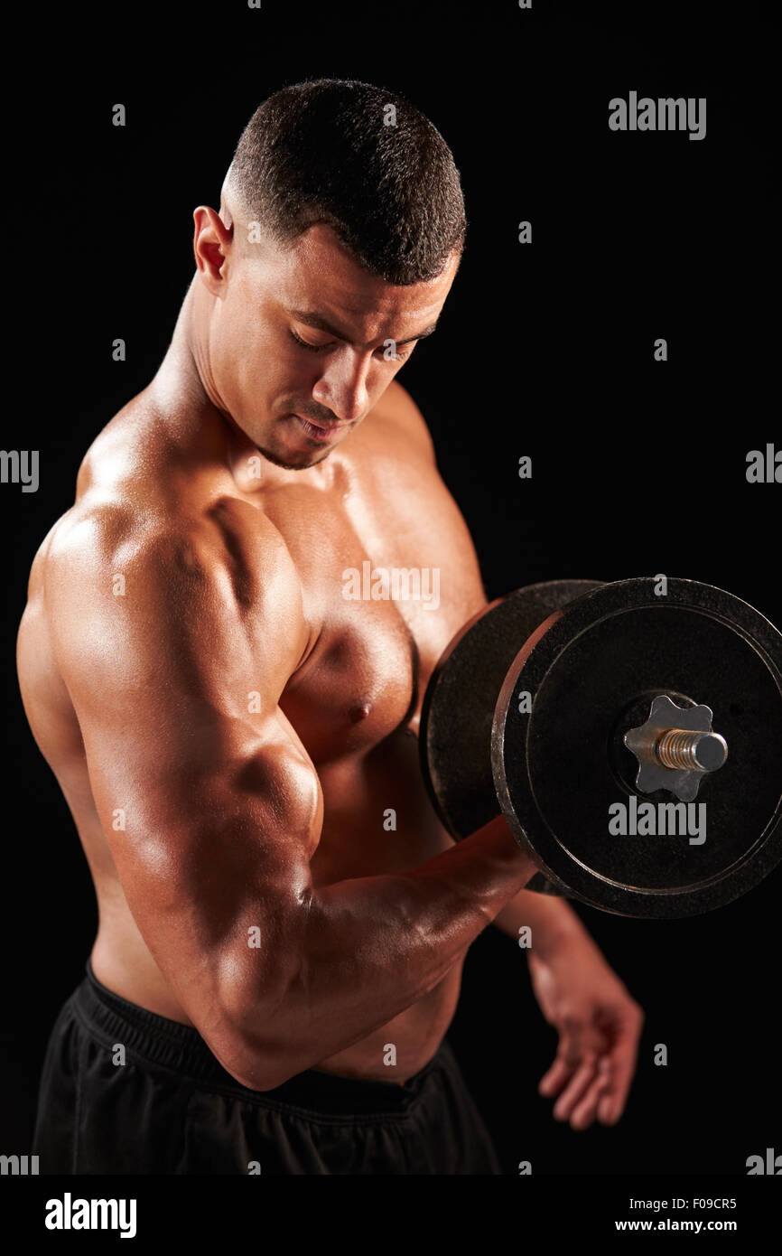 Muscular young man working out with heavy dumbbell Stock Photo - Alamy