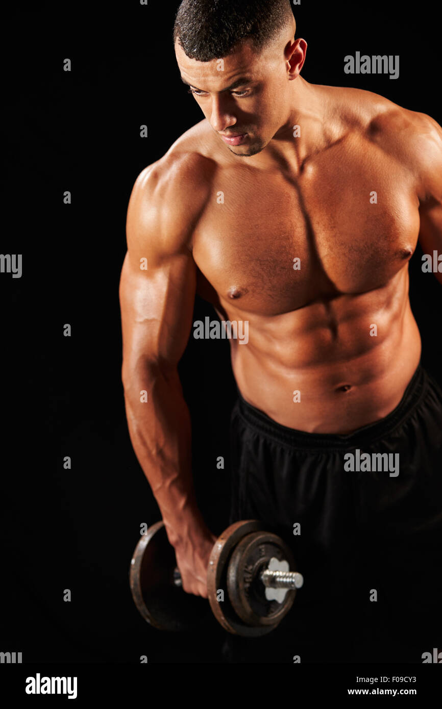 Muscular young man working out with heavy dumbbell Stock Photo - Alamy