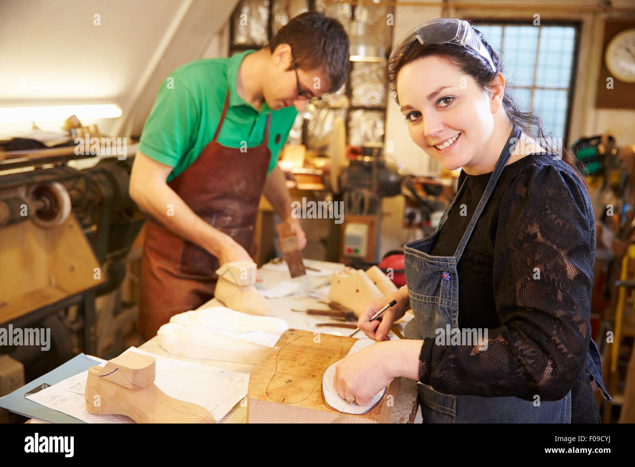 Two young shoemakers preparing shoe lasts in a workshop Stock Photo - Alamy