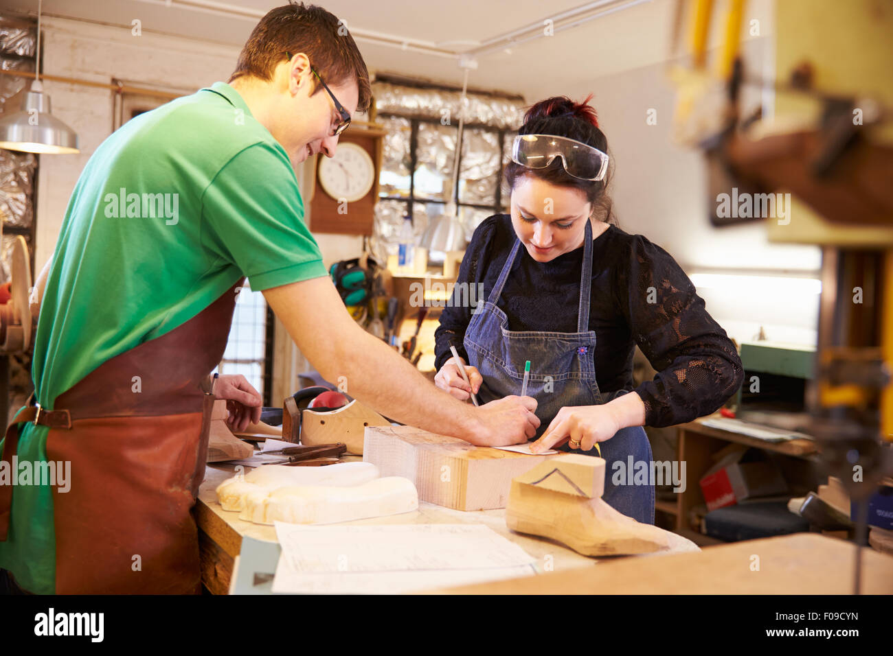 Two young shoemakers preparing shoe lasts in a workshop Stock Photo - Alamy