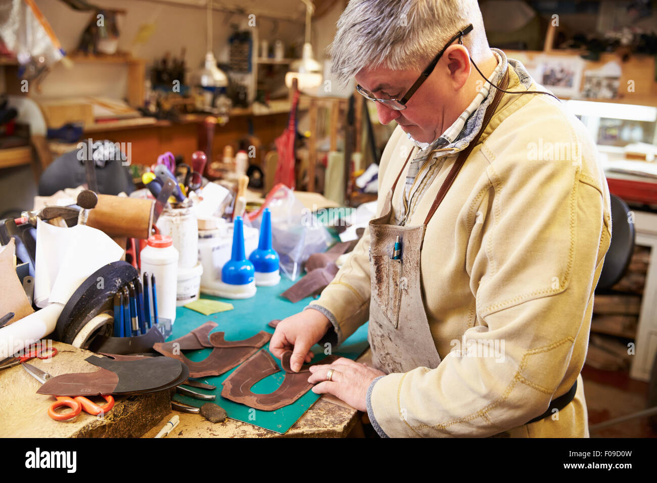 Shoemaker cutting and gluing leather in a workshop Stock Photo - Alamy