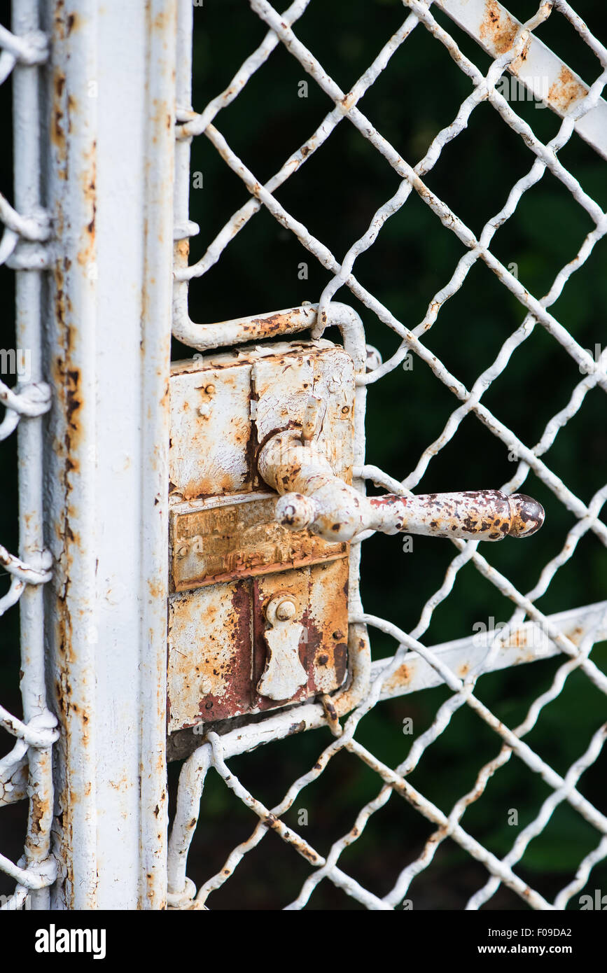 rusty door handle with a lock in the old gate Stock Photo - Alamy