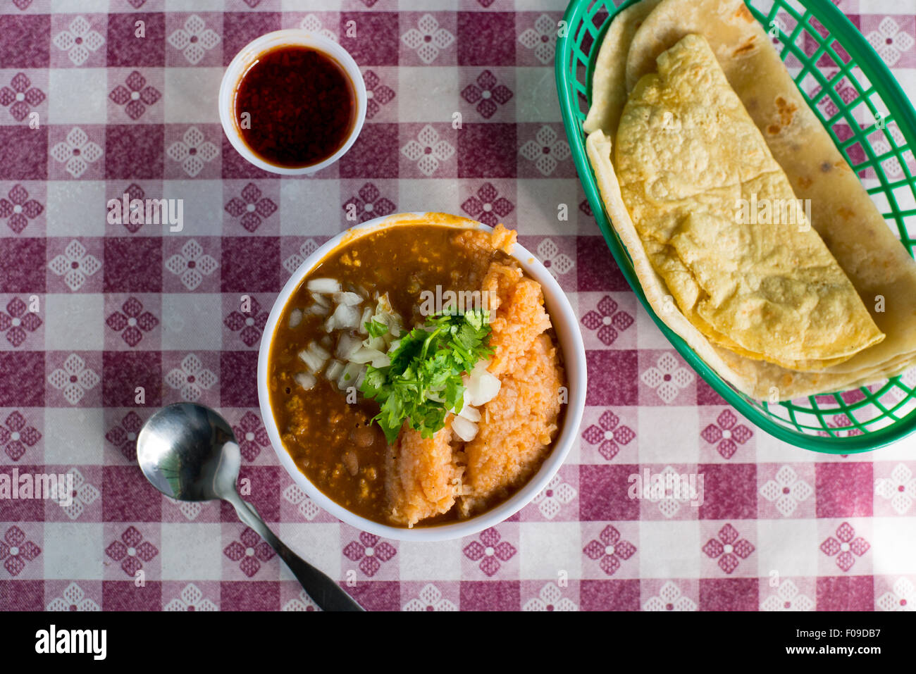 Overhead view of taco components: rice, beans, and pork in a small bowl ...