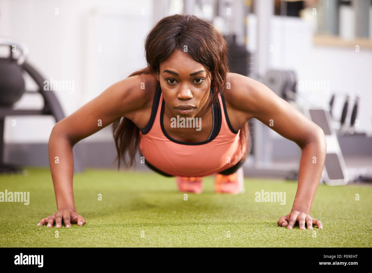 Young woman doing push ups at a gym Stock Photo - Alamy