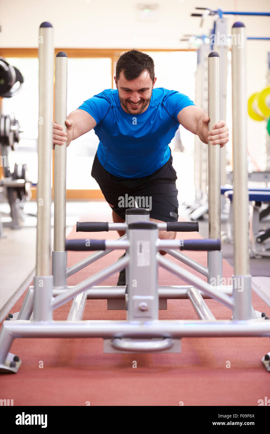 Young man working out using equipment at a gym, vertical Stock Photo ...
