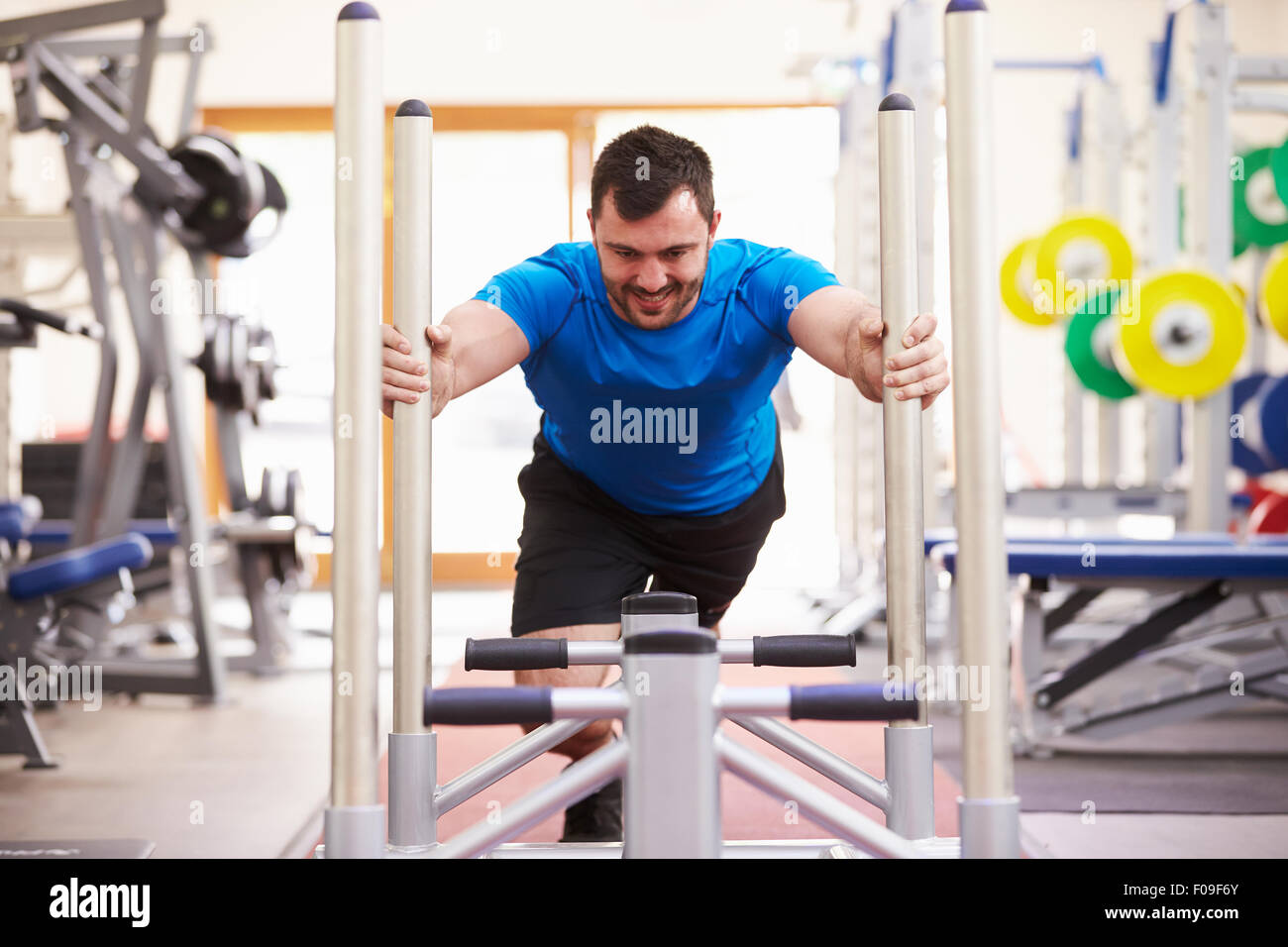 Young man working out using equipment at a gym Stock Photo - Alamy