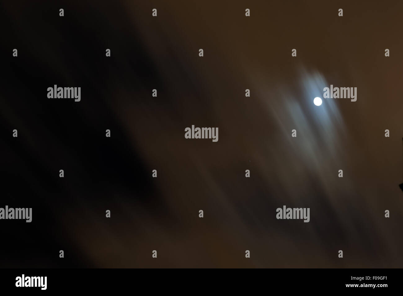 Night picture of the moon showing in a gap between clouds Stock Photo ...