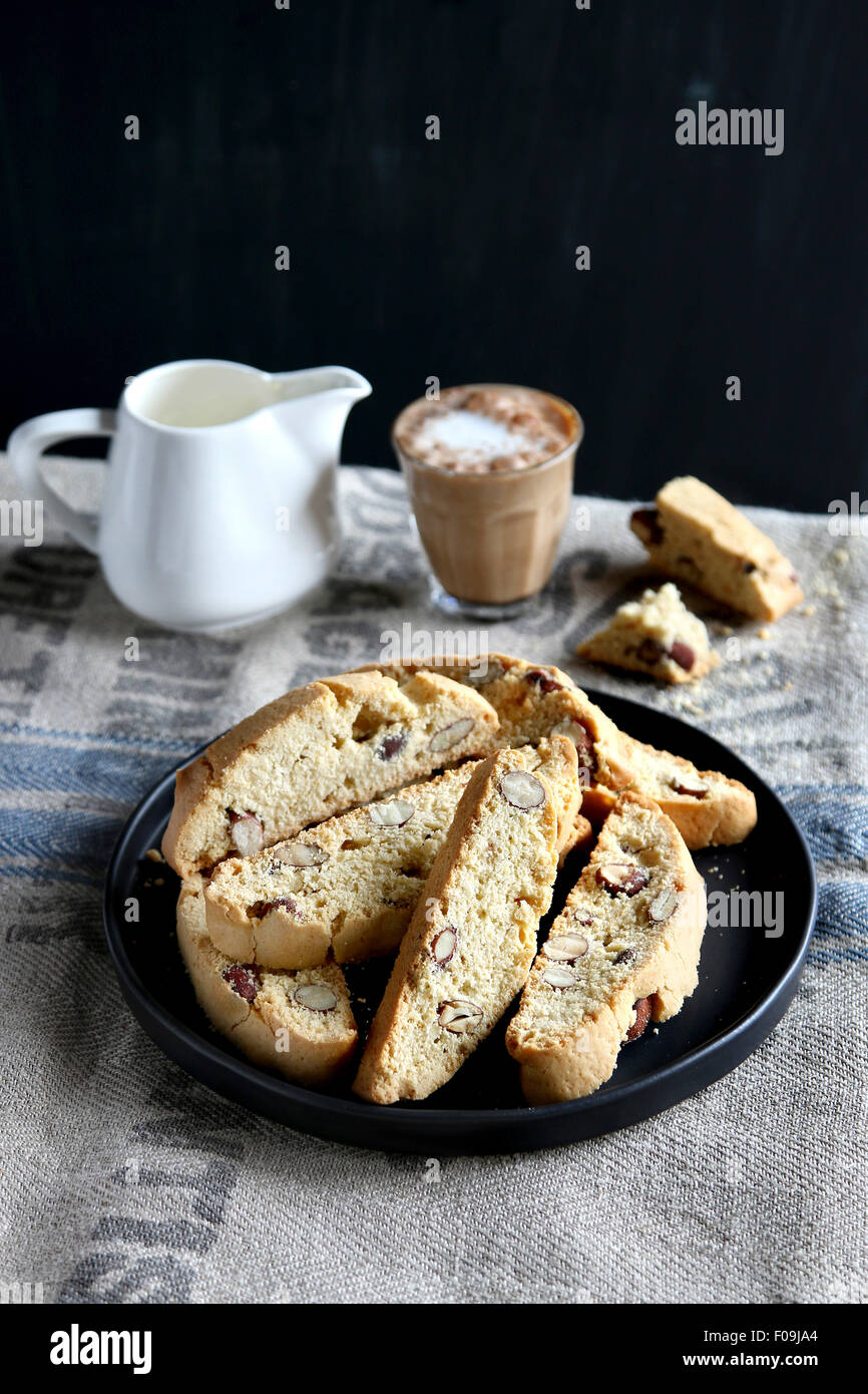 Almond Italian biscotti on a plate with a glass of coffee and a jug of ...