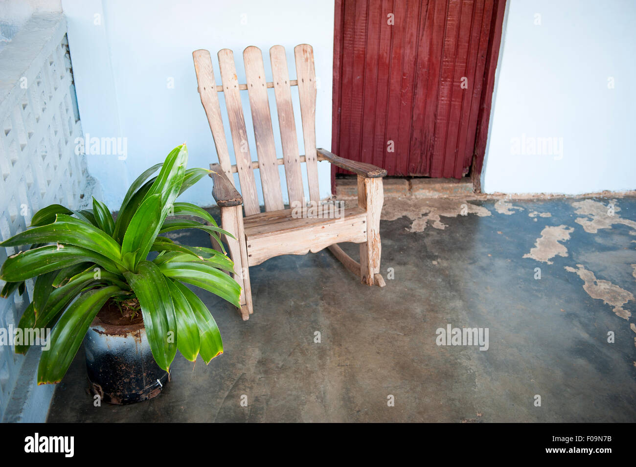 Traditional wooden rocking chair on the rustic front porch of a rural ...
