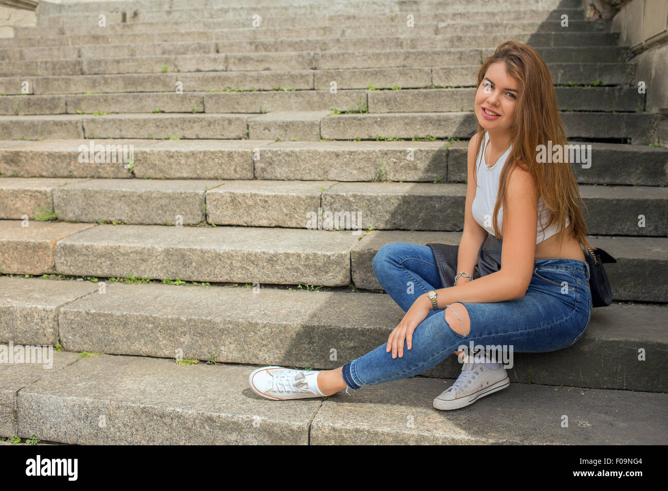 Portrait of a smiling woman sitting on steps Stock Photo - Alamy