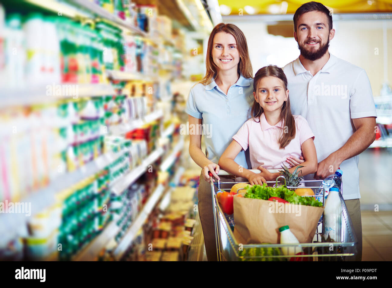 Caucasian family looking at camera in modern hypermarket Stock Photo ...