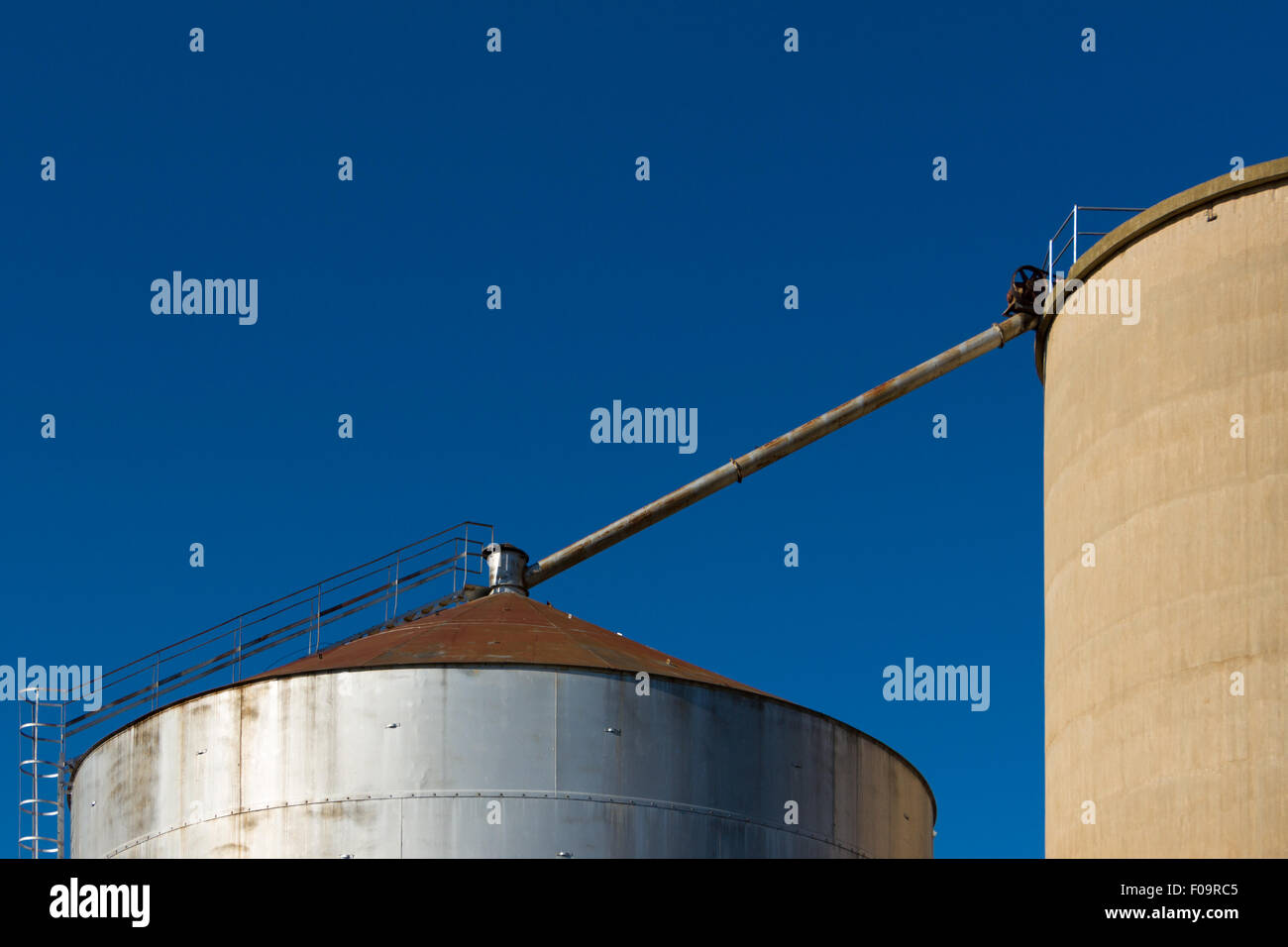 A close up of the top of large silos on a blue sky Stock Photo - Alamy