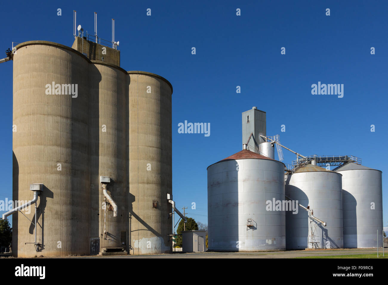 Large concrete and steel silos on blue sky Stock Photo - Alamy