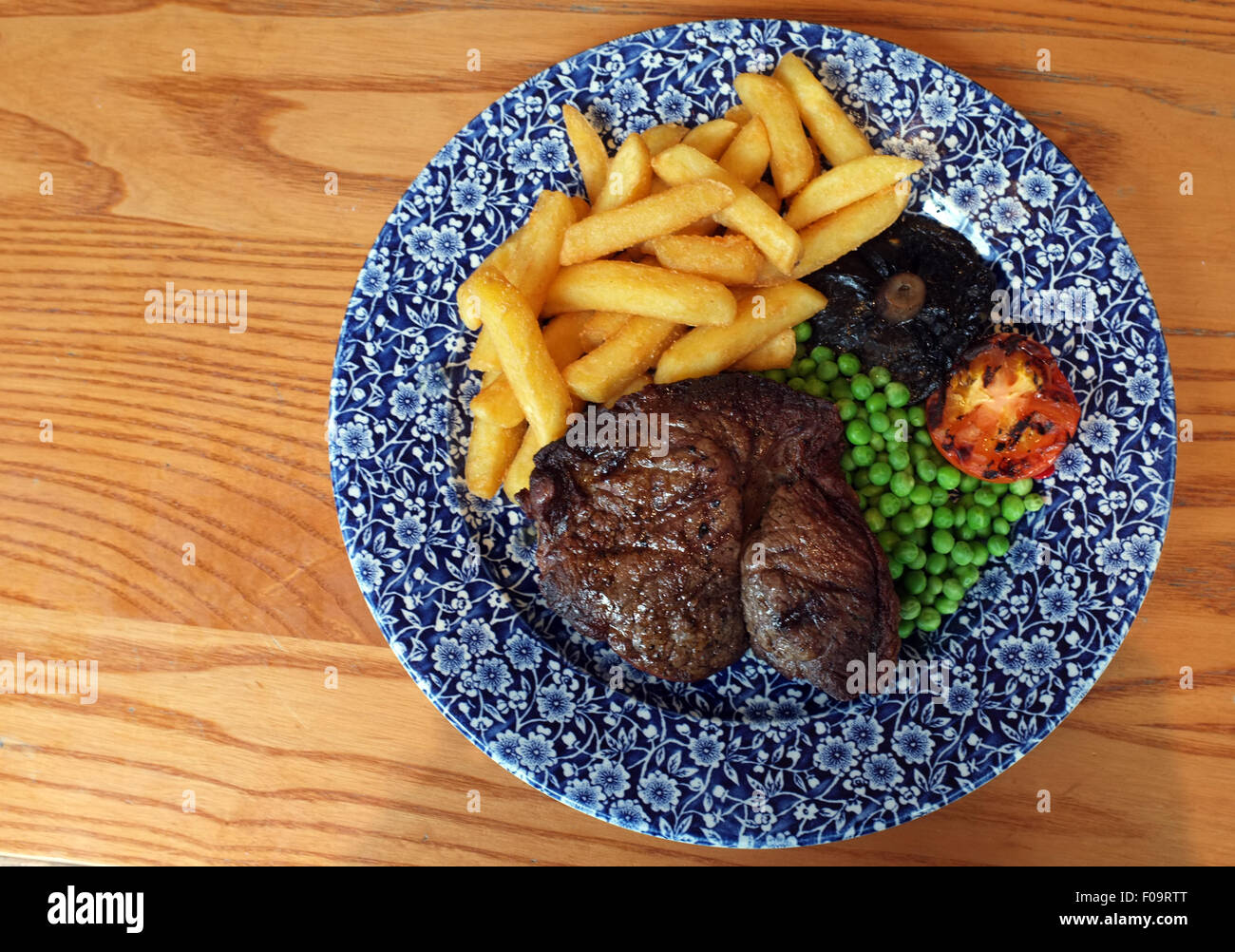Steak & Chips meal on a blue and white plate Stock Photo - Alamy