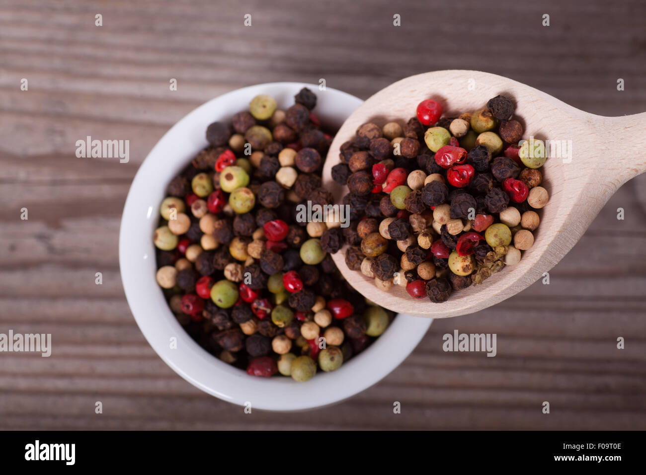 Pepper mixture on spoon over wooden background Stock Photo - Alamy