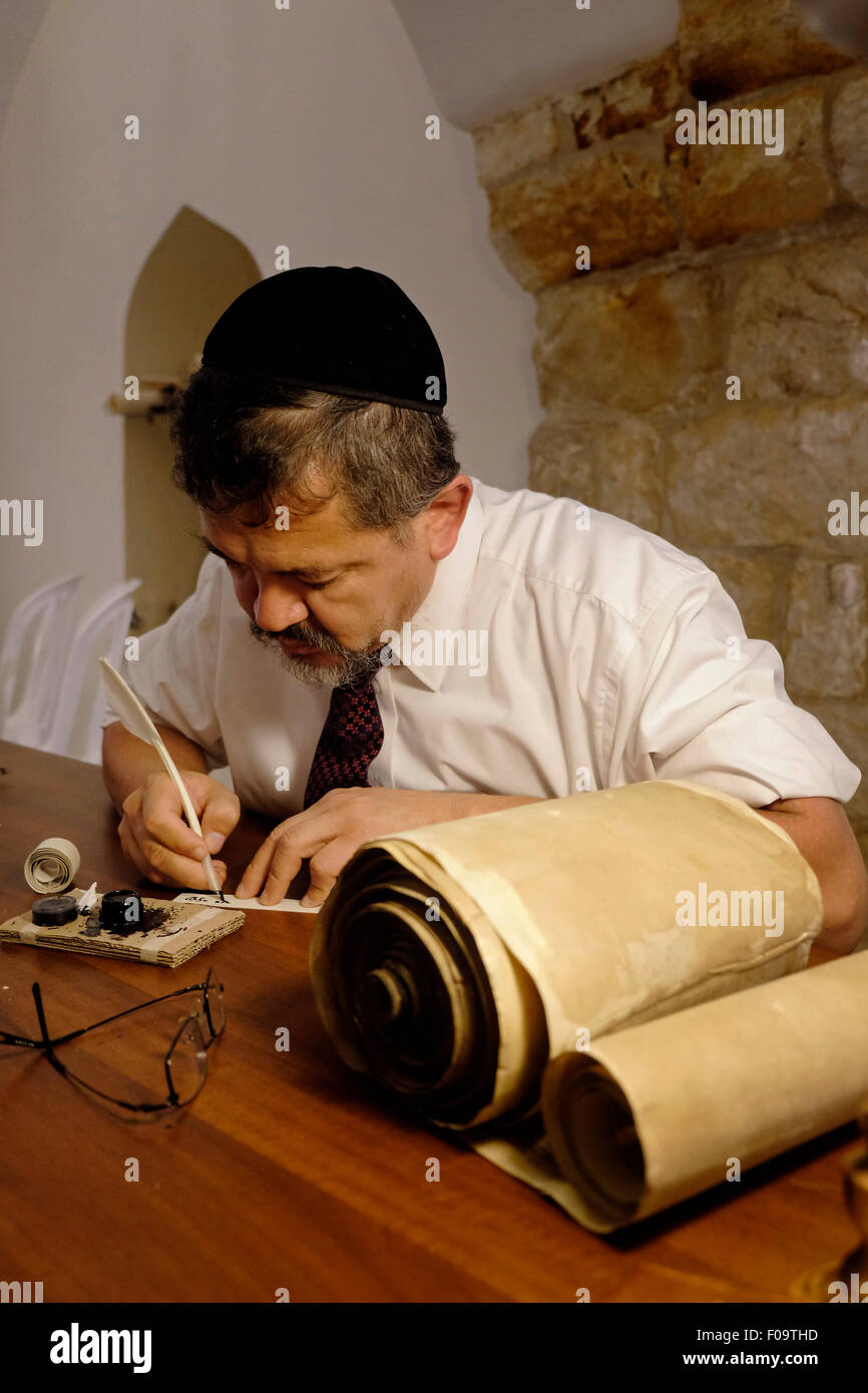A religious Jewish "Stam" calligrapher writing a Hebrew script on ...