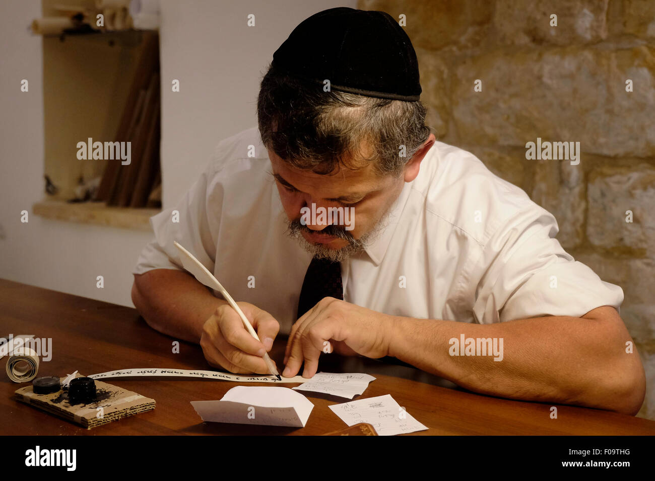 A religious Jewish "Stam" calligrapher writing a Hebrew script on ...