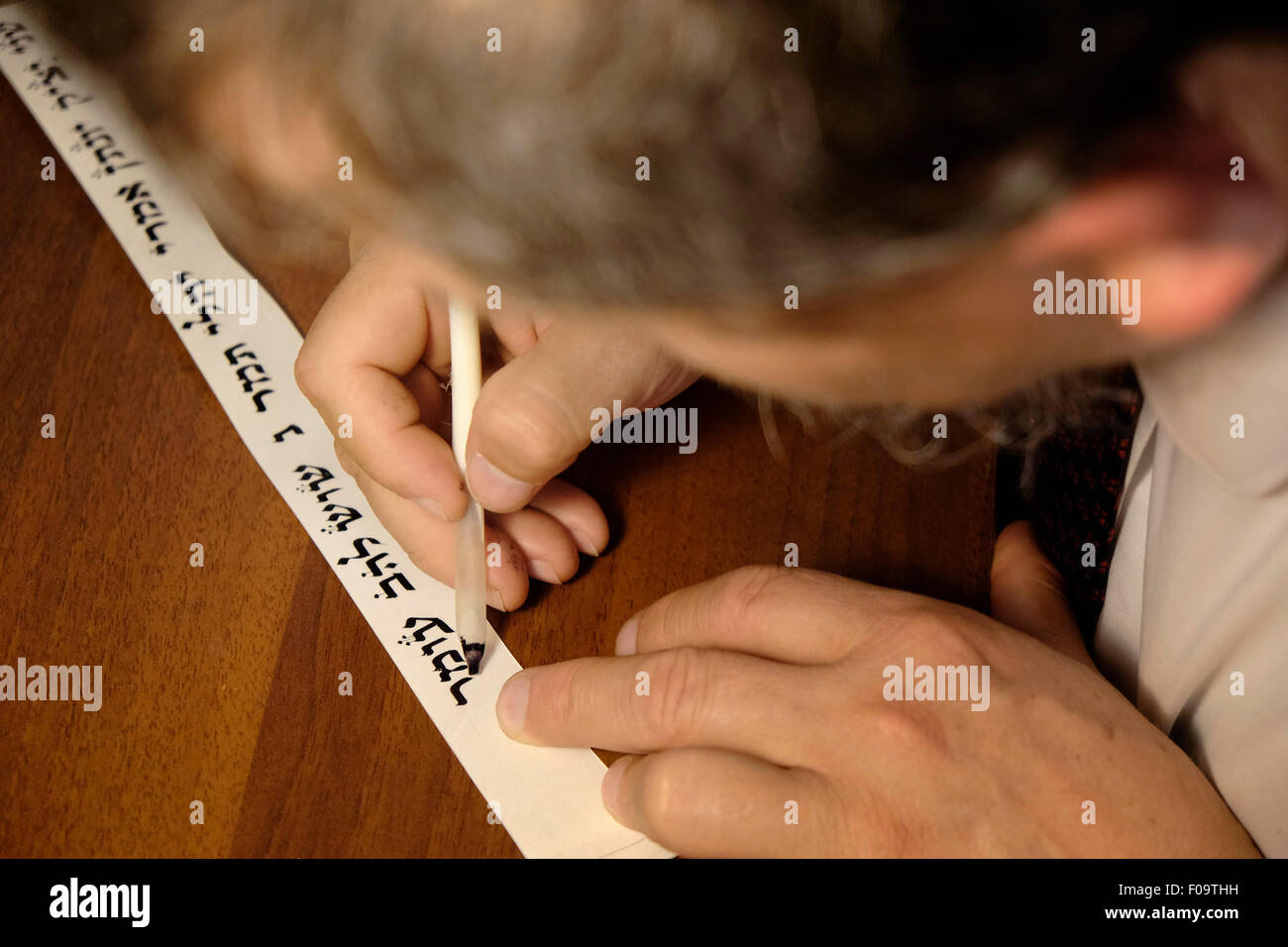 A religious Jewish "Stam" calligrapher writing a Hebrew script on ...