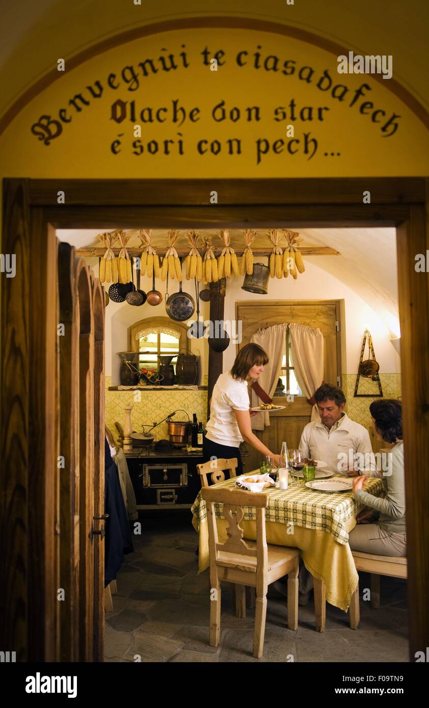 Waitress serving people in room of hut Rifugio Fuciade, Trentino Stock ...