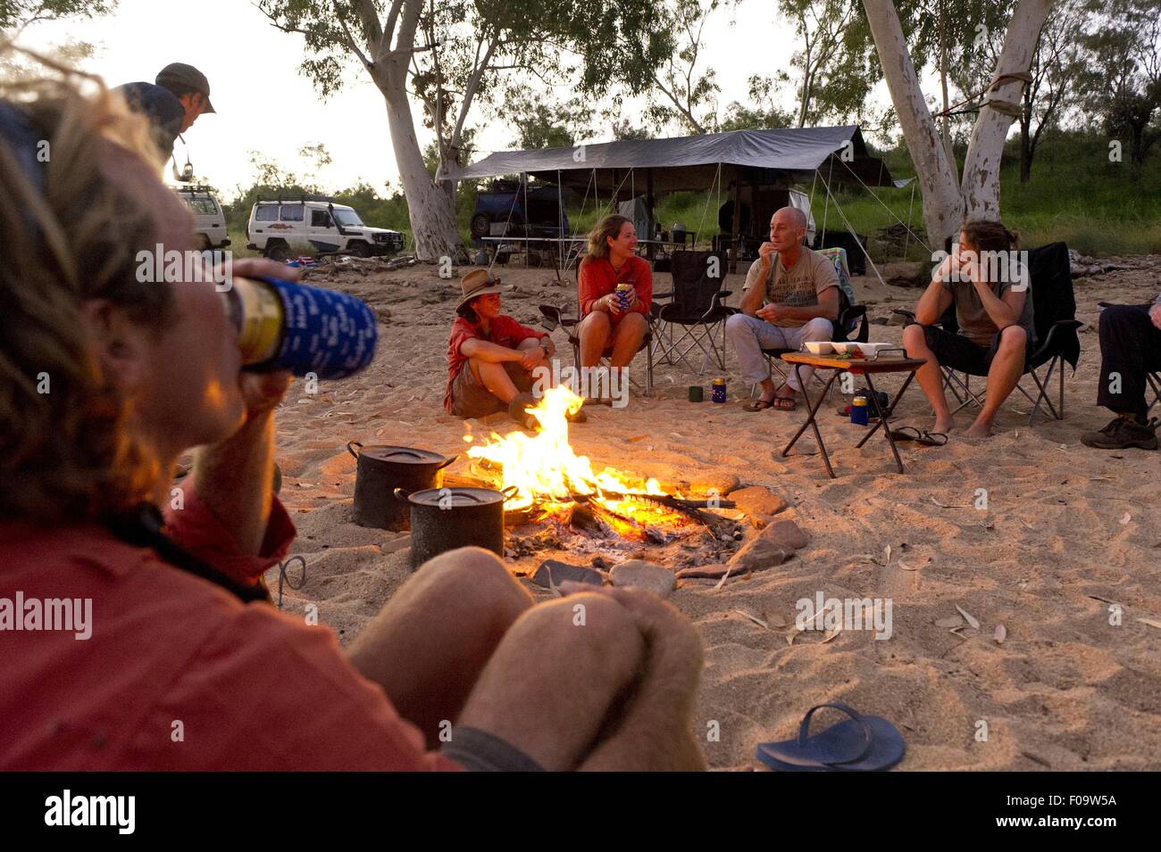 People sitting around camp fire in Ormiston Creek, Alice Springs ...