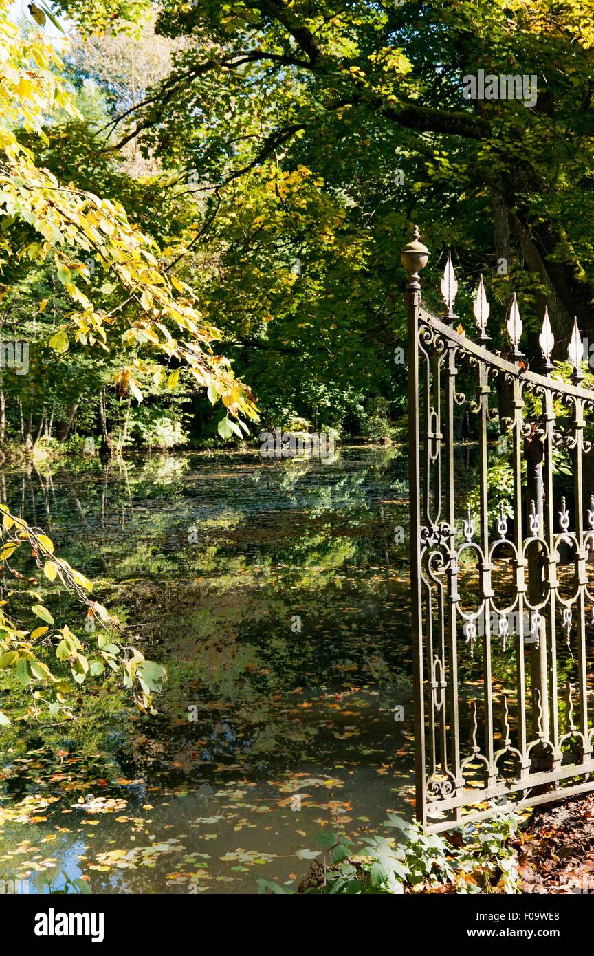 View of castle pond and trees through open gate Stock Photo - Alamy