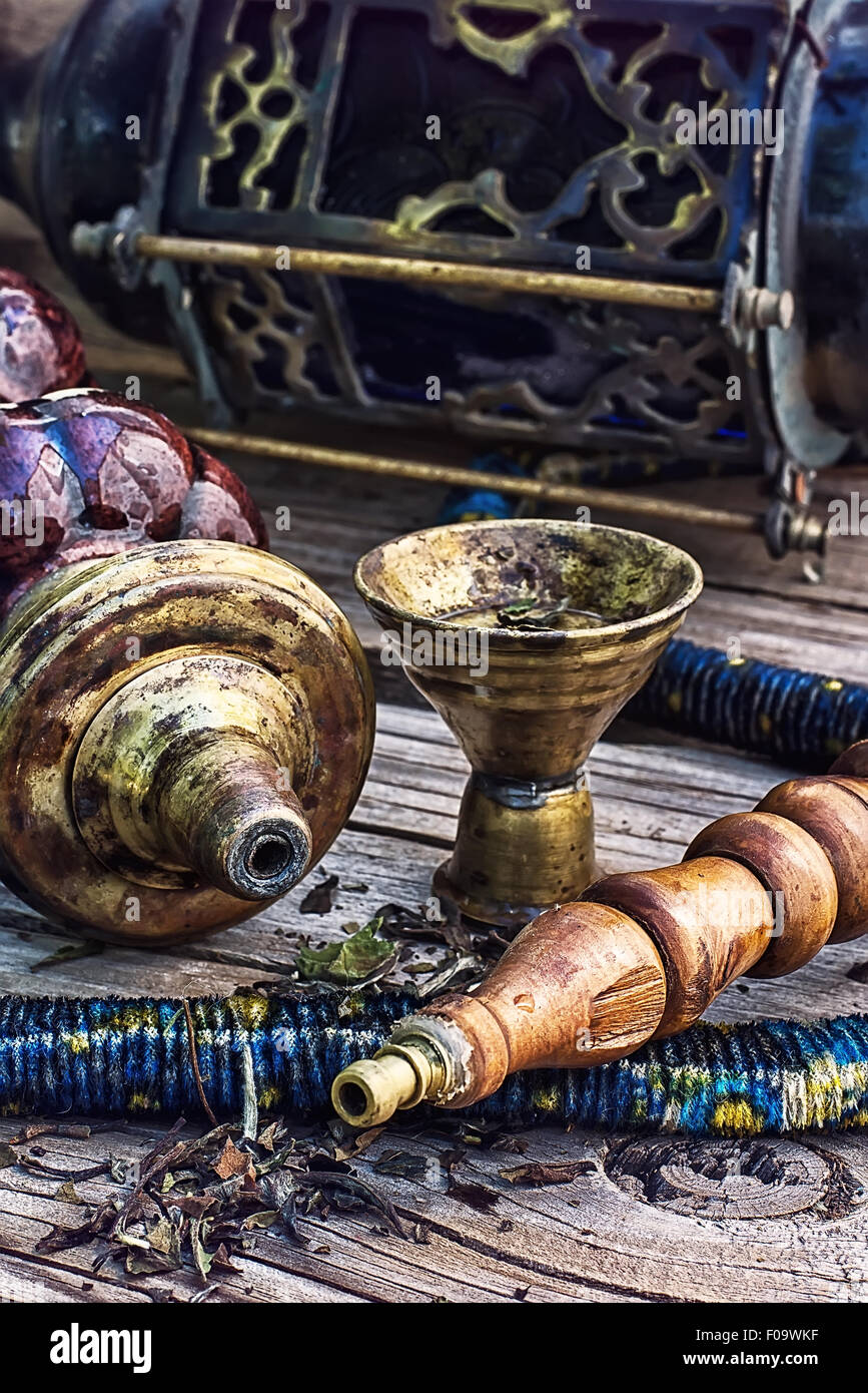Old smoking hookah on wooden surface.Photo tinted Stock Photo - Alamy
