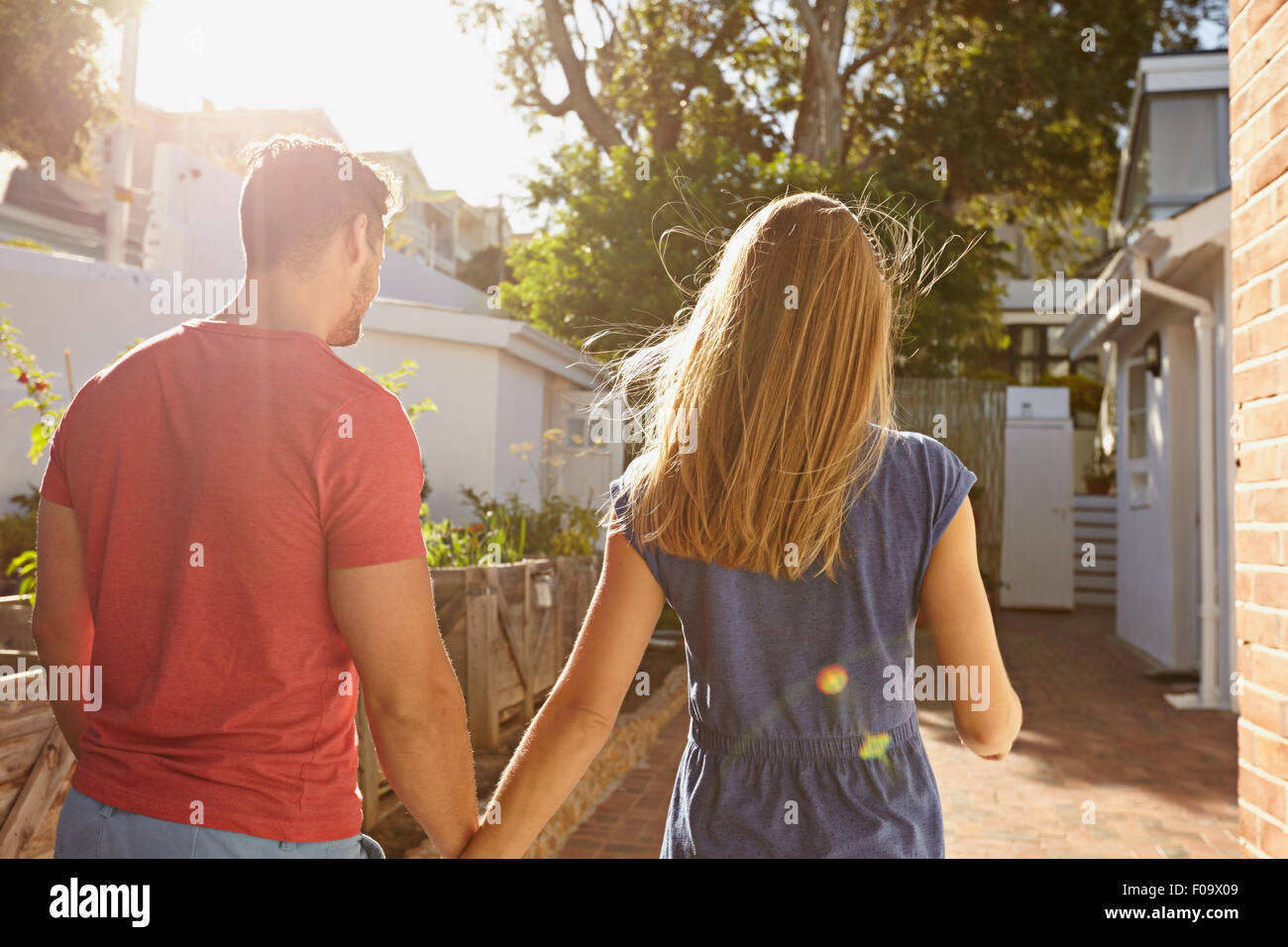 Rear view of young couple walking at their house together. Couple in ...