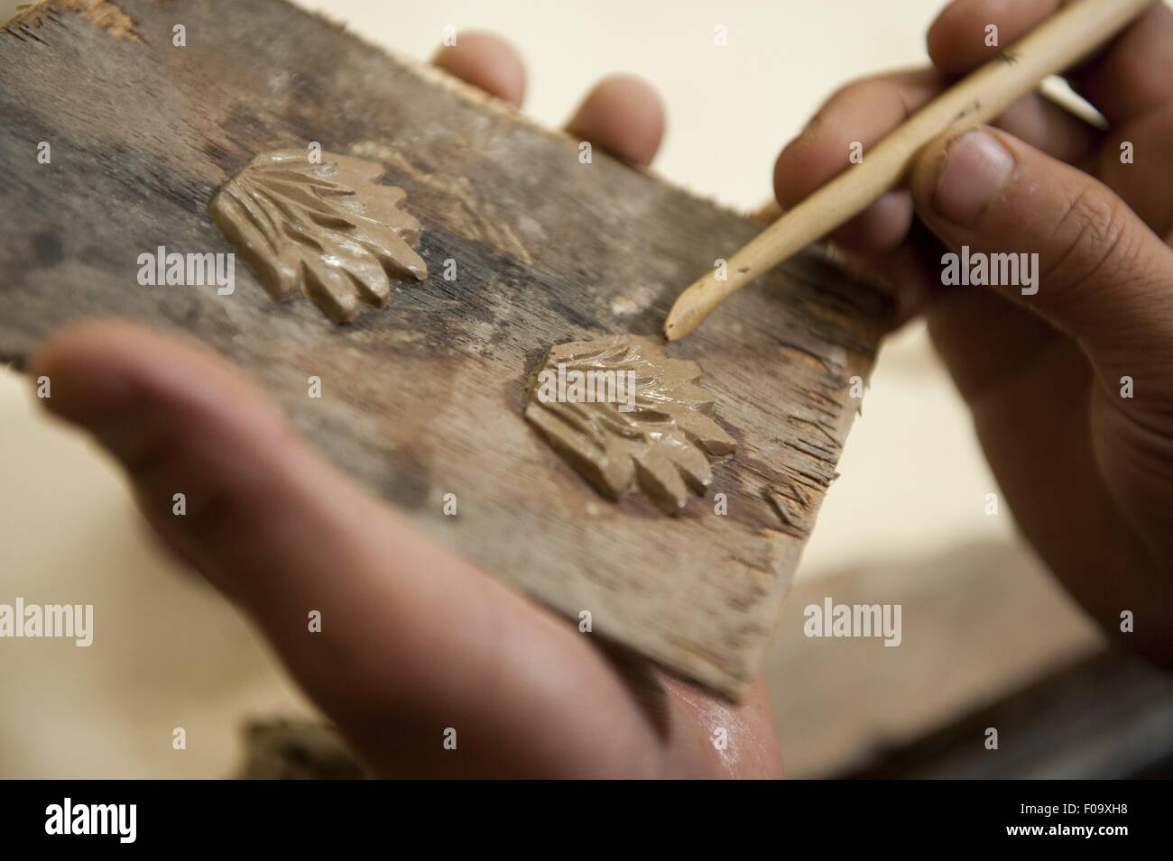 Close-up of human hand making clay art with stick at art school in ...