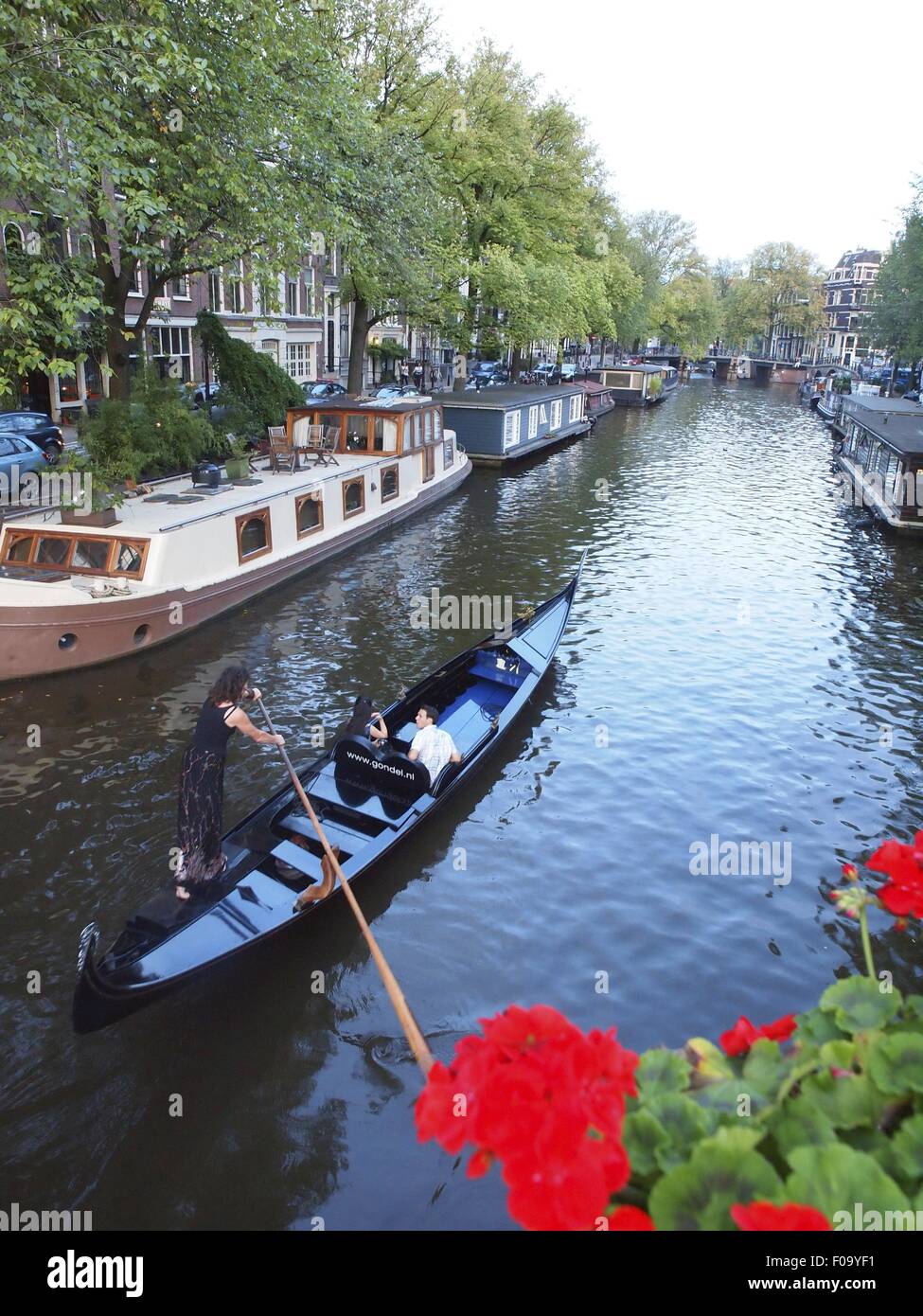 Tourists enjoying gondola ride in Prinsengracht canal, Amsterdam ...