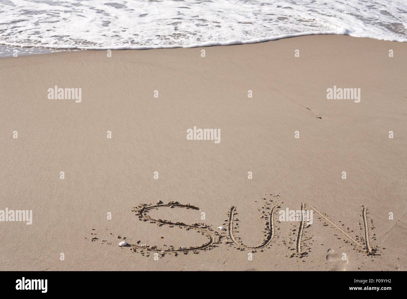 Sun written on sand on beach Stock Photo - Alamy