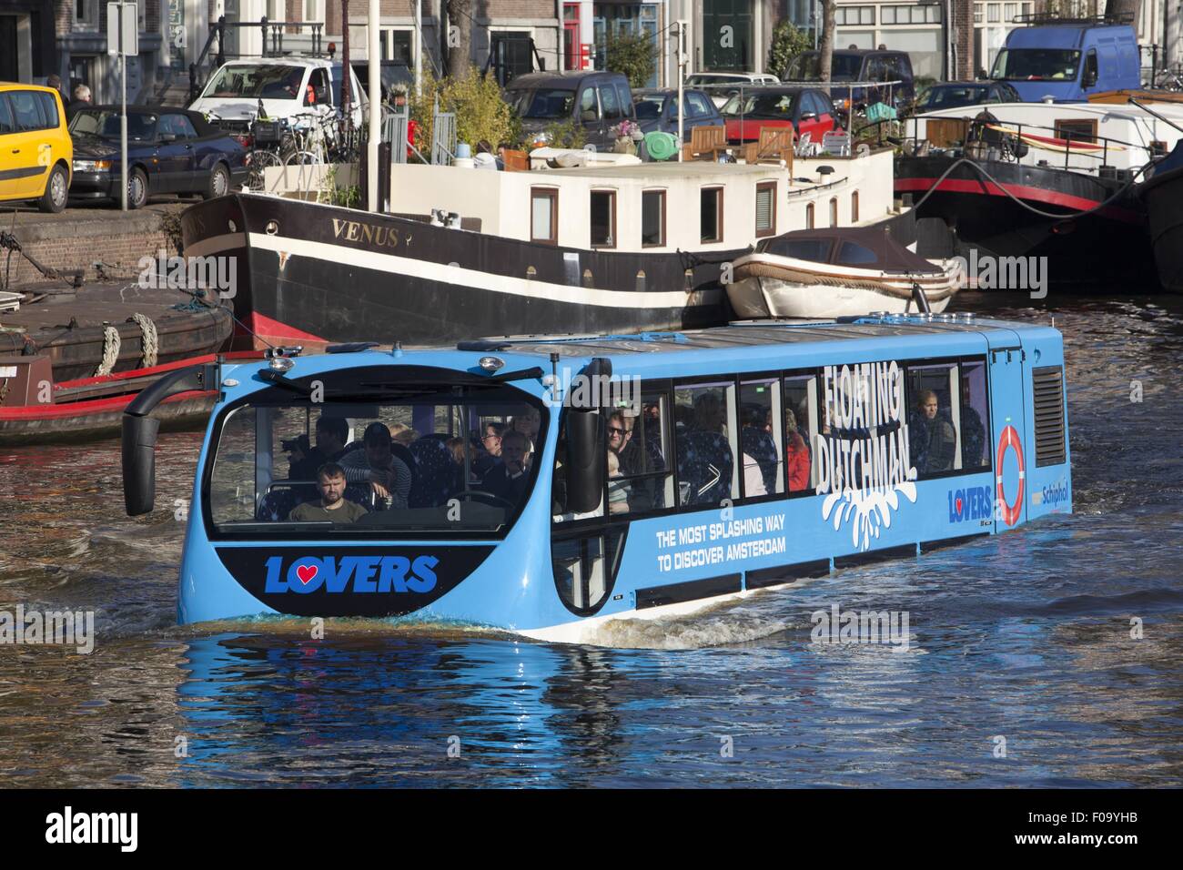 People travelling in floating bus in Oudeschans, Amsterdam, Netherlands ...