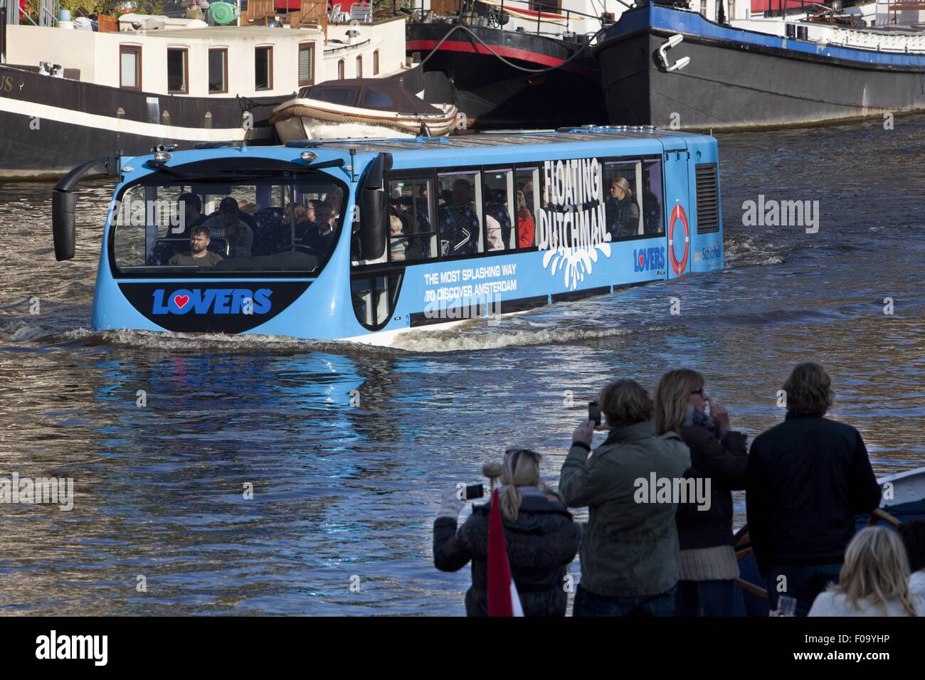 People travelling in floating bus in Oudeschans, Amsterdam, Netherlands ...