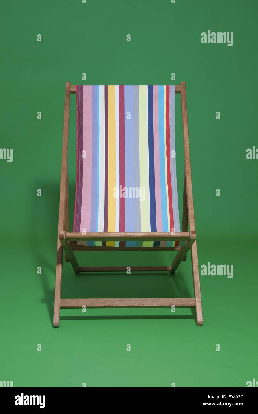 Folding deck chair with stripes pattern on green background Stock Photo ...