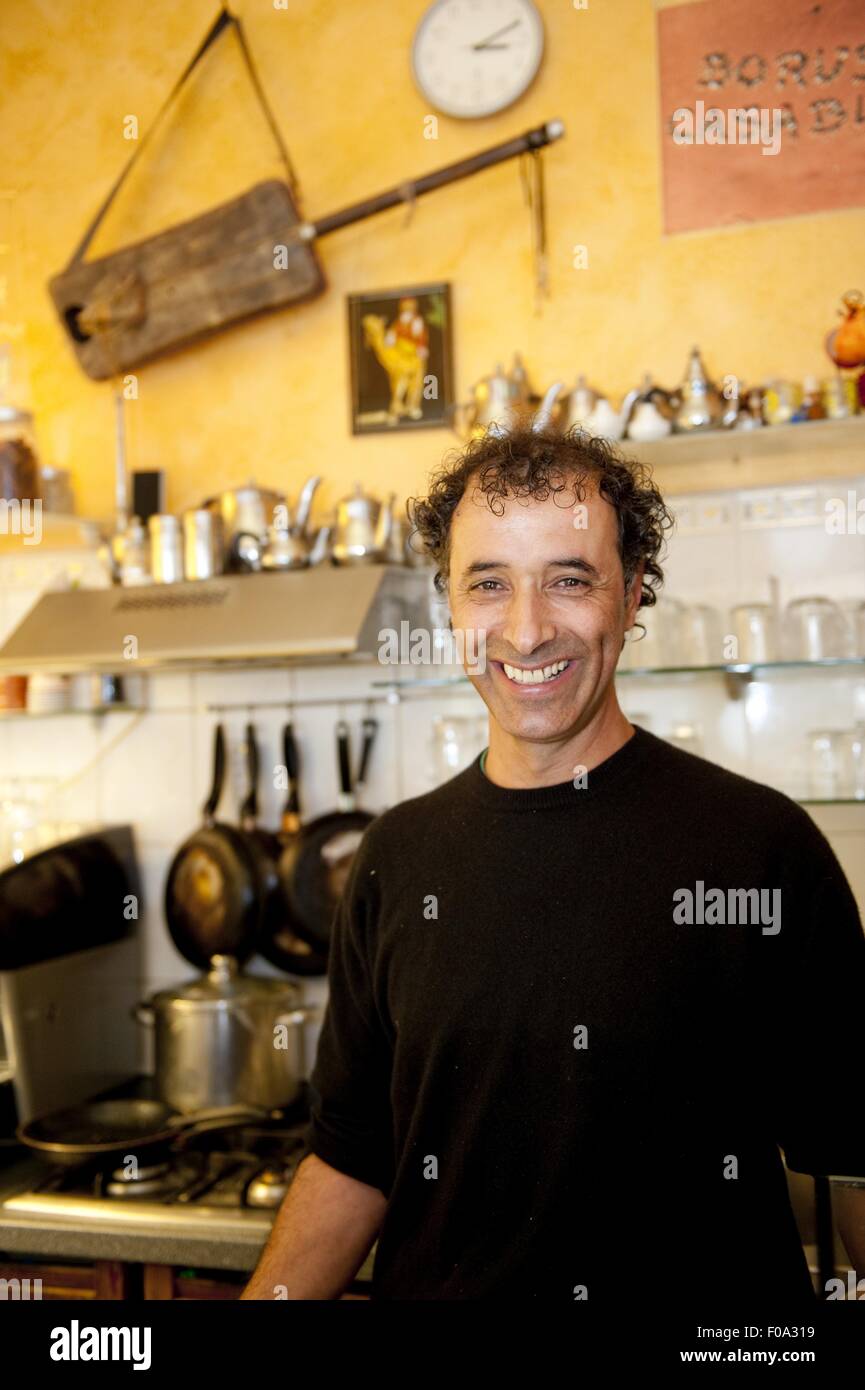 Portrait of man standing in kitchen and smiling, Kalk, Cologne, Germany ...