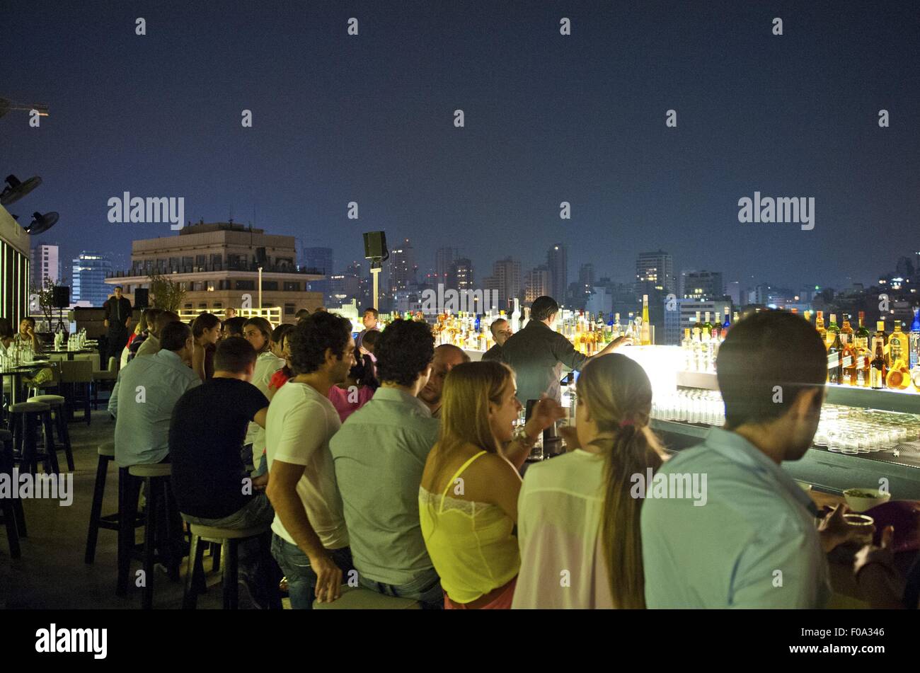 People sitting on rooftop bar Le Capitole overlooking city of Beirut ...