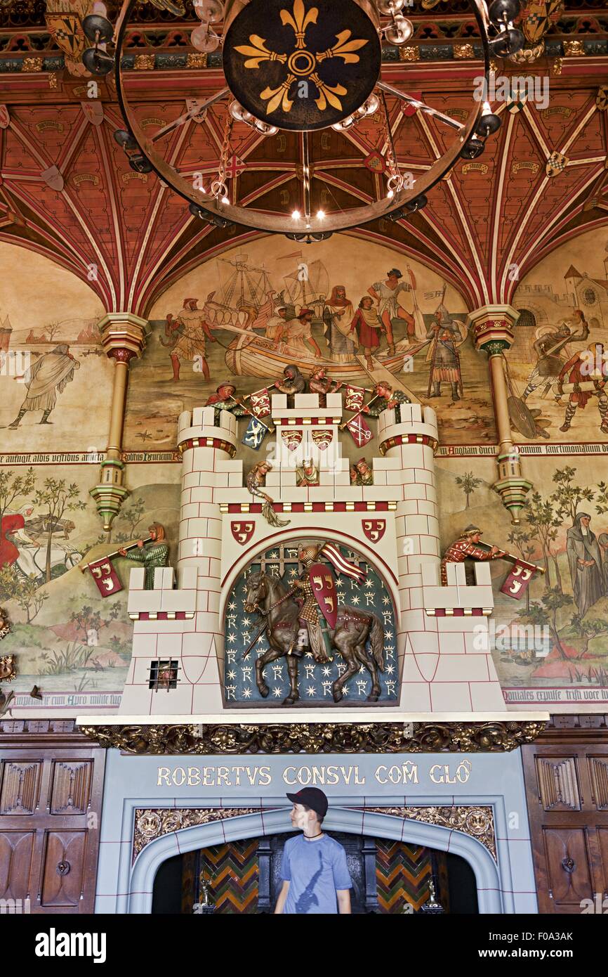 Man standing and looking away at Cardiff castle with murals and statue ...
