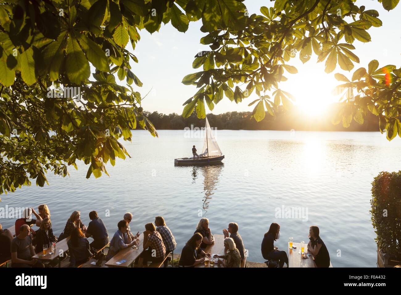 People sitting at Maschseefest beer garden with ferry in background ...