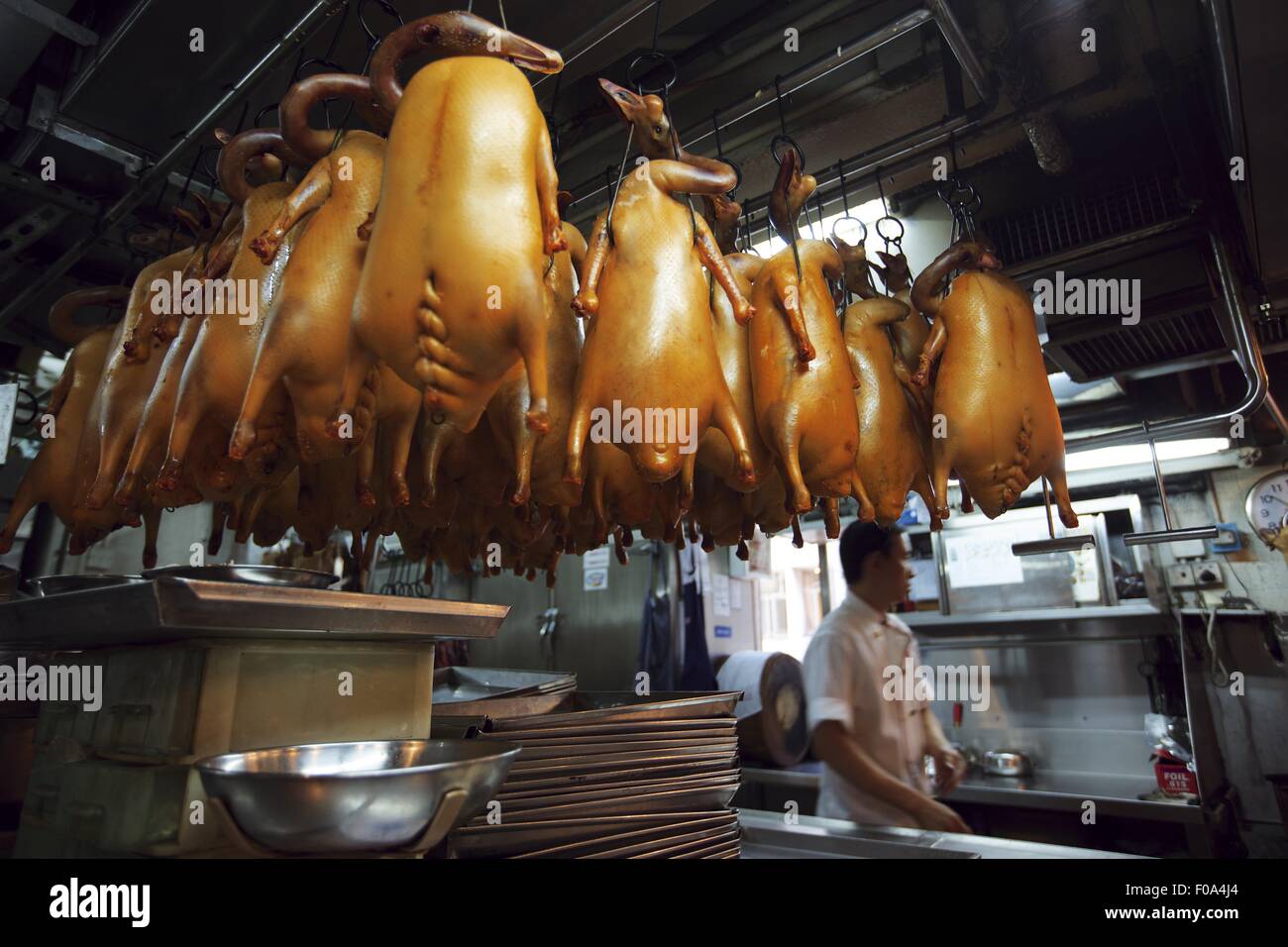 Chef in kitchen with hanging roasted goose in Yung Kee Restaurant, Hong ...