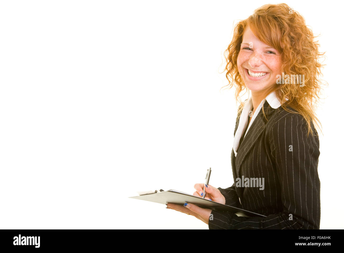 Smiling young woman with clipboard taking notes Stock Photo - Alamy