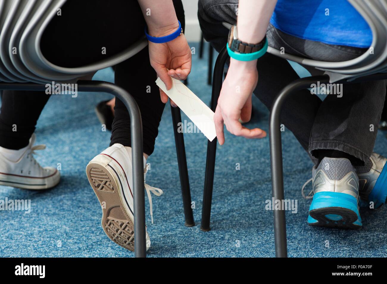 Classmates passing secret note in classroom Stock Photo - Alamy