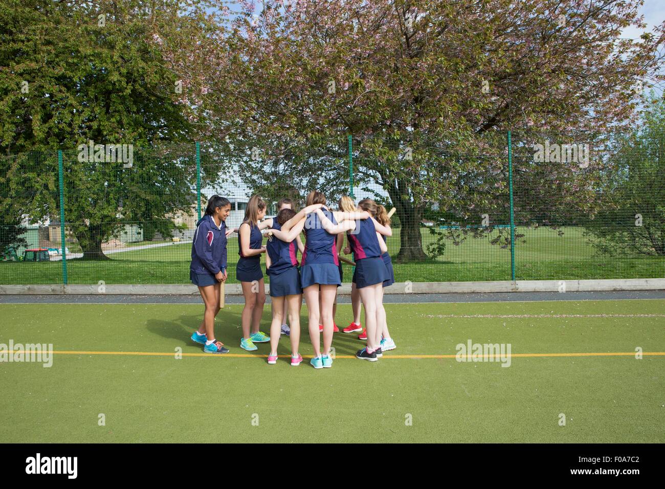 Group of students in a huddle in field Stock Photo - Alamy