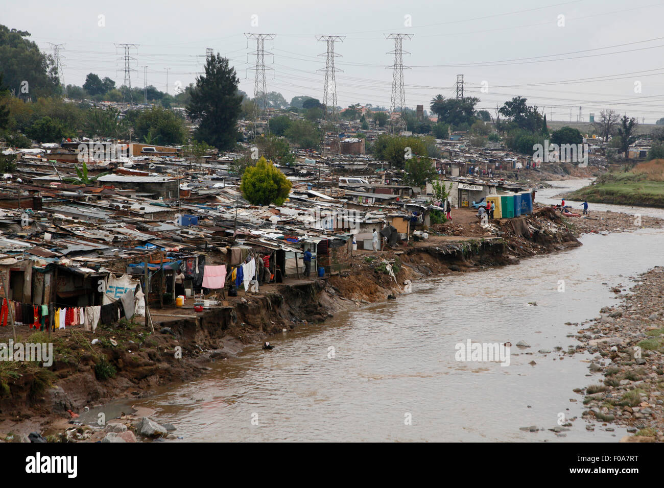 Shacks on the banks of the Jukskei river the morning after heavy rain ...