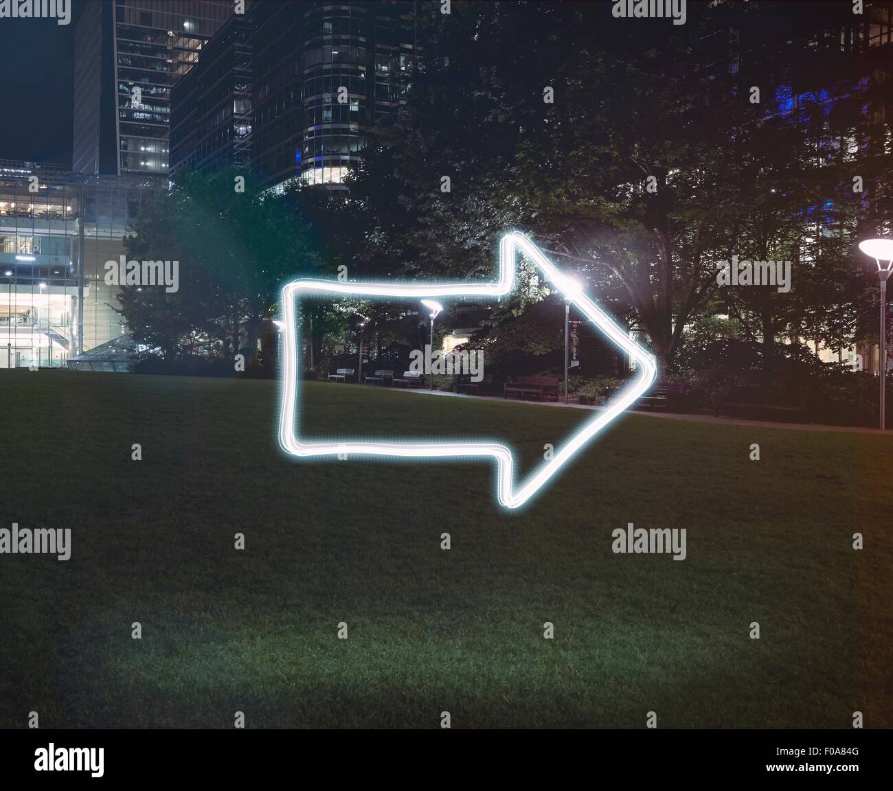 Glowing direction arrow pointing right at night, London, UK Stock Photo ...