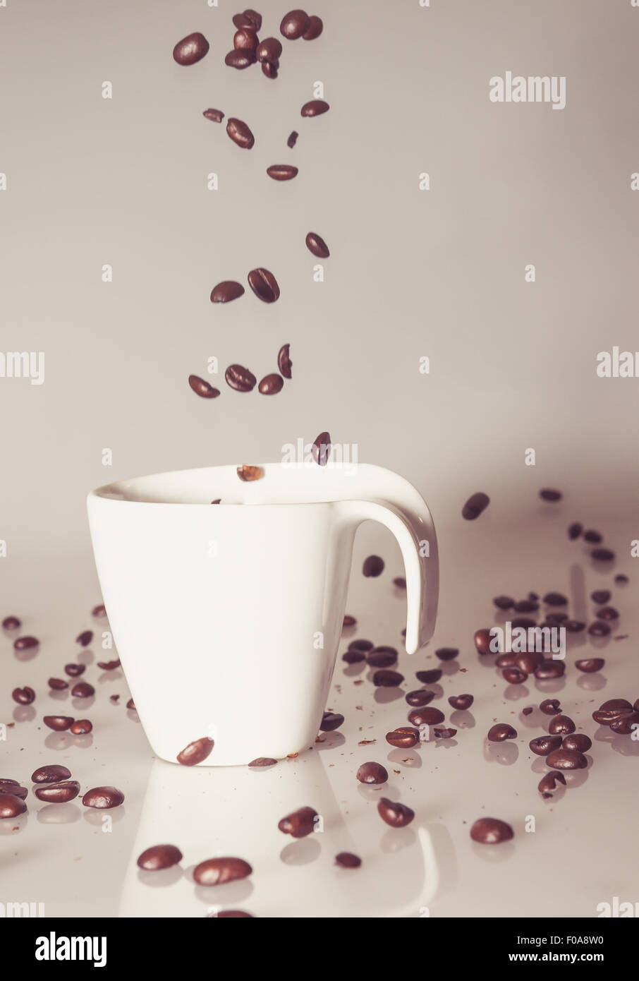 Coffee beans falling into the coffee cup Stock Photo - Alamy
