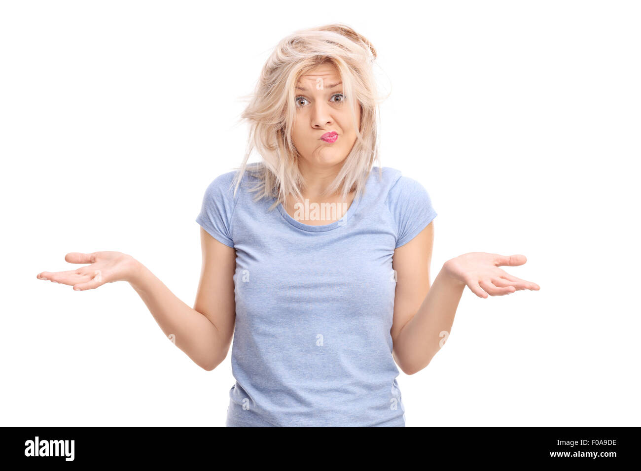 Confused blond girl with a messy hair gesturing with her hands and ...