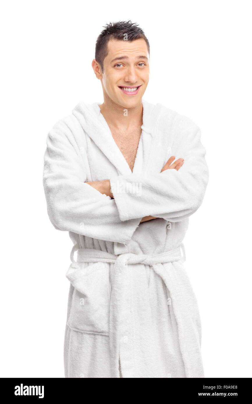 Vertical shot of a cheerful young guy posing in a white bathrobe ...