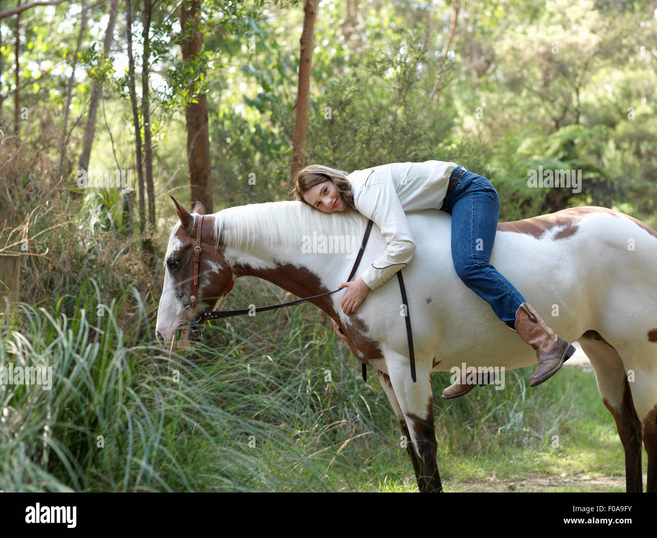 Portrait of teenage girl hugging horse whilst bareback riding Stock ...