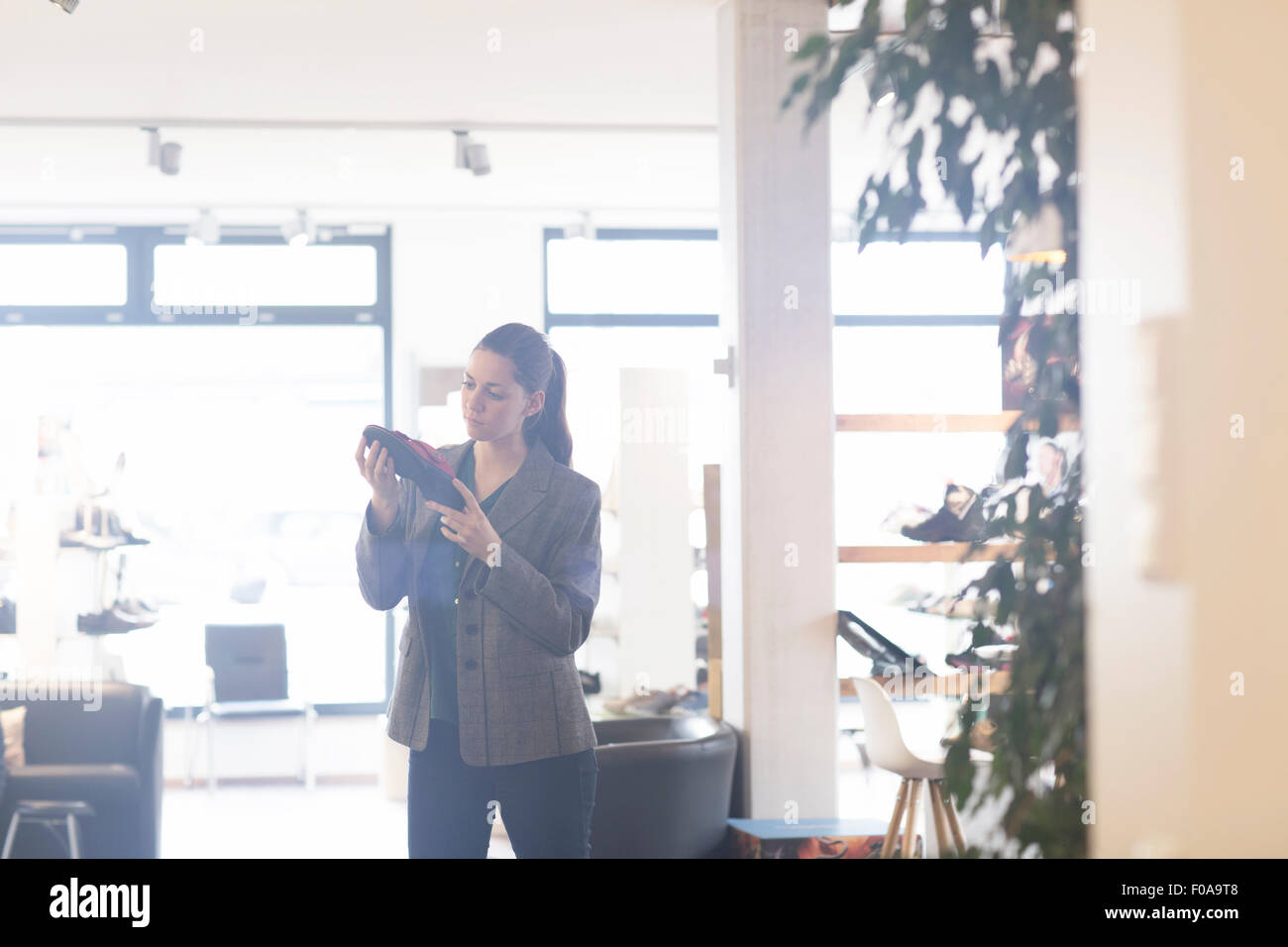 Young female shopper selecting sandal in shoe shop Stock Photo - Alamy